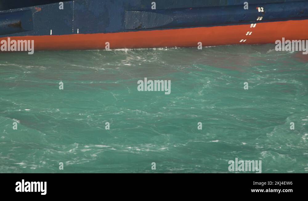 detail of ship close up side of ship red and blue paint sea with small ...