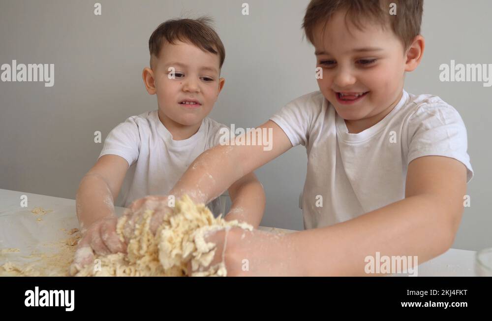 Two small children prepare something from the dough. A two boys are ...