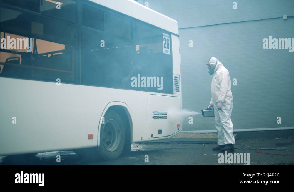 One person in hazmat disinfects a city bus. Disinfect, disinfection ...