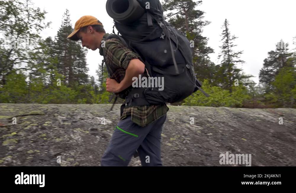 Person hiking with large and heavy backpack in challenging terrain in ...