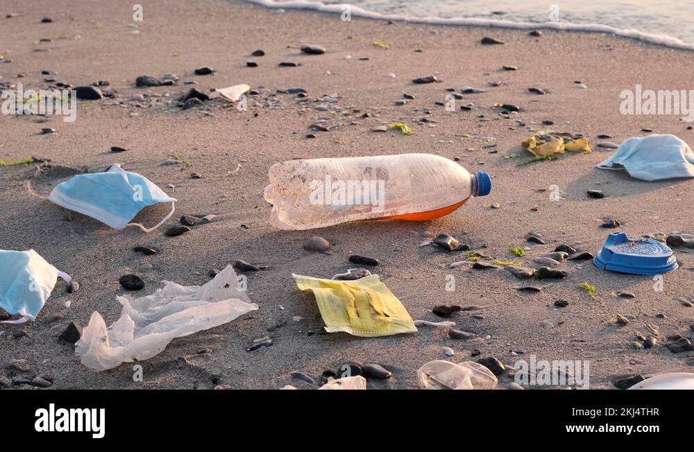 Disposable face masks and plastic debris on the beach in surf zone ...