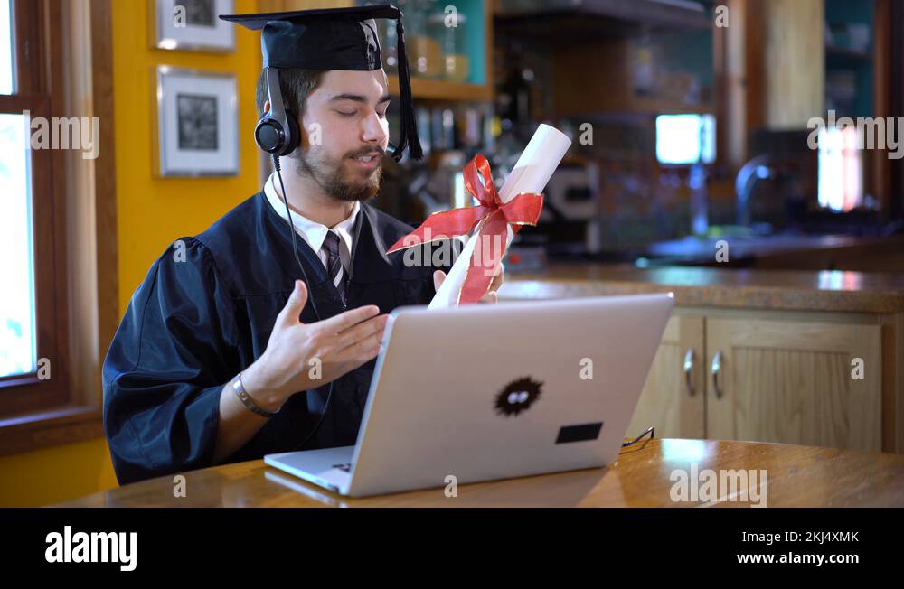Wearing a graduation costume and headset, an online graduate talks to ...