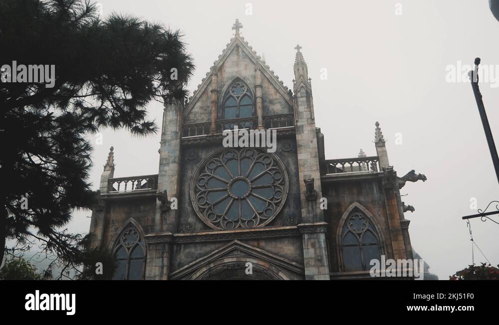 old gothic cathedral with large windows and a windmill standing in a ...