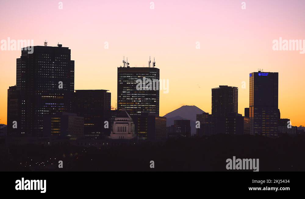 Mount Fuji appears in the sunset among the high-rise buildings at Tokyo ...