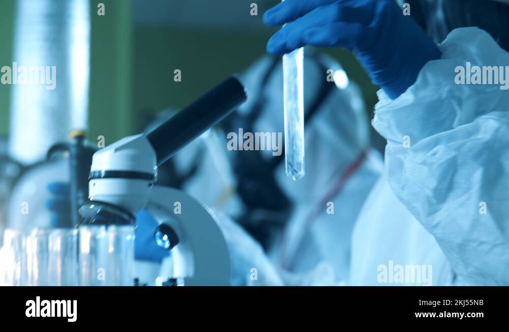 Laboratory specialist is observing a sample under a microscope. Covid ...