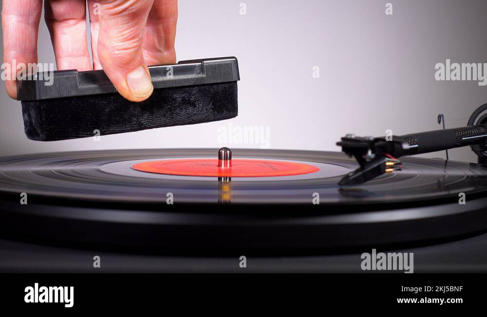 Cinemagraph – Man holding dust cleaner above a vinyl LP revolving on ...