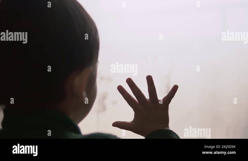 Little kid touching the glass window full of condensation missing going ...