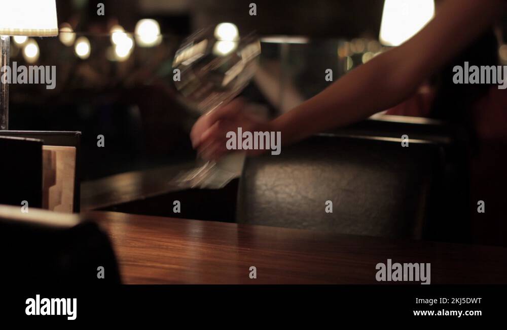 Staff at a fine dining restaurant set the table for the next guest ...