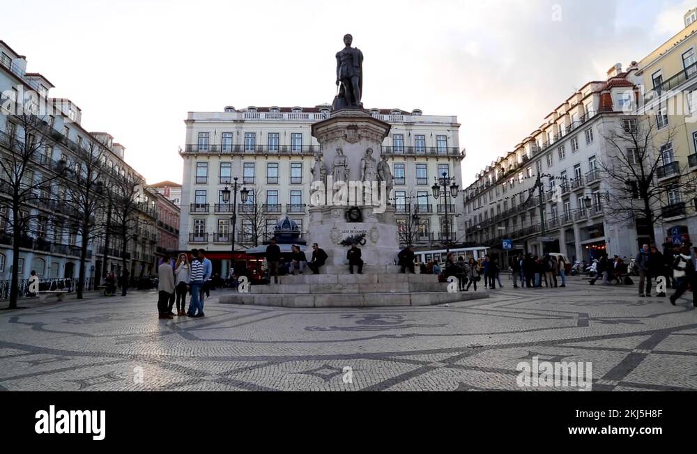 People walking around the statue of Portuguese poet Luis de Camoes in ...
