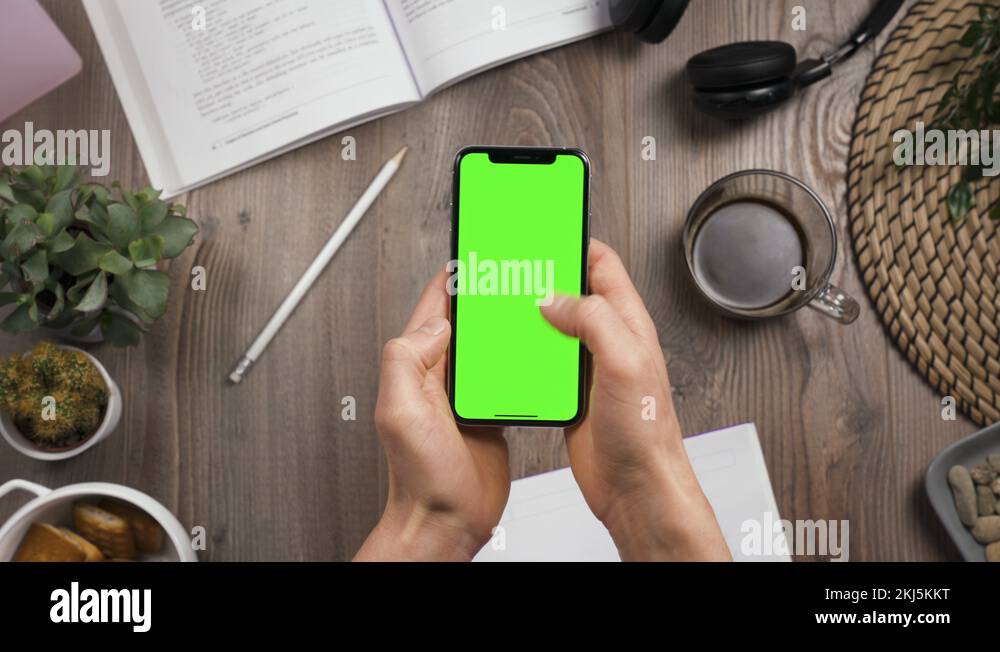 Phone with green screen chroma key in male hands. Thumb swipe up and ...