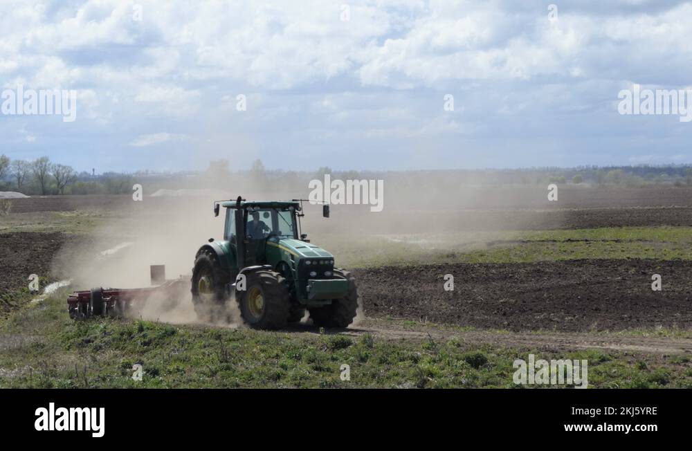 Farmer on Tractor Plowing Dusty Arid Soil. Farm Car Followed. Tractor ...