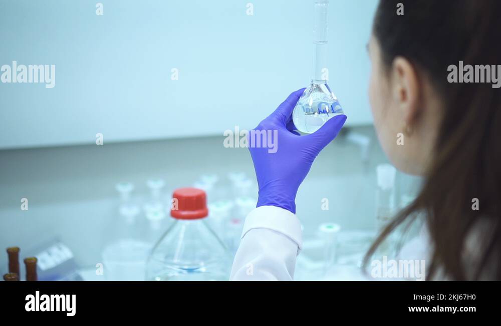 woman scientist holding lid flask and pipette in chemistry laboratory ...