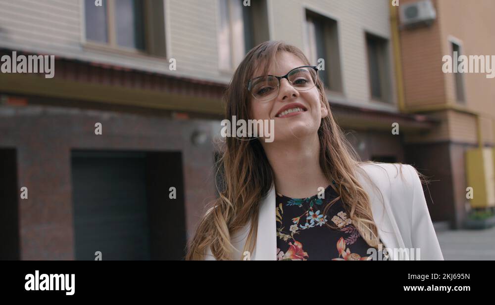 Pretty girl with cup of street coffee poses with smile at camera in ...