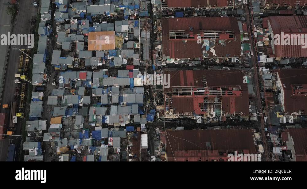 Descending bird's eye view aerial flight over slums revealing busy ...