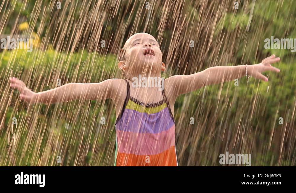 Cute little girl having fun in rainy at backyard on rainy day Stock ...