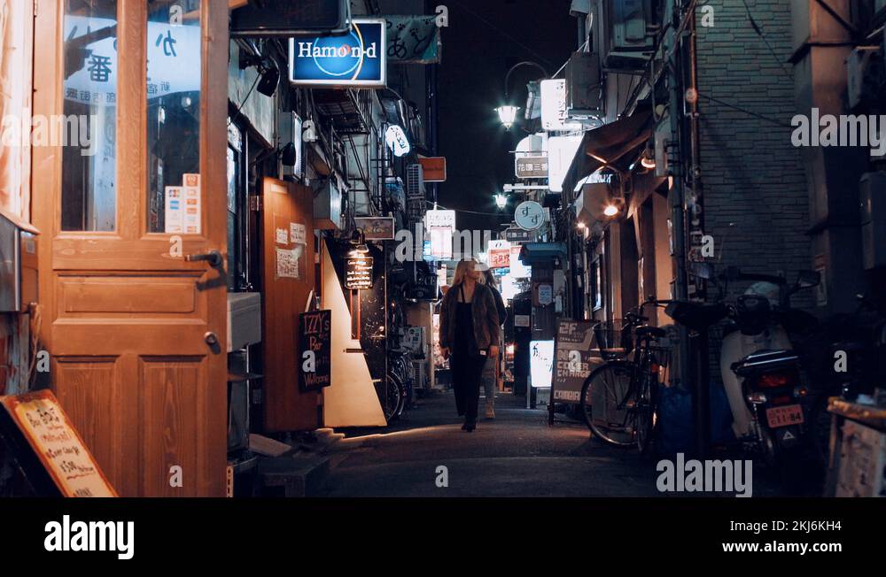 Tokyo nightlife people. Women walking in Golden Gai narrow alley. Bar ...