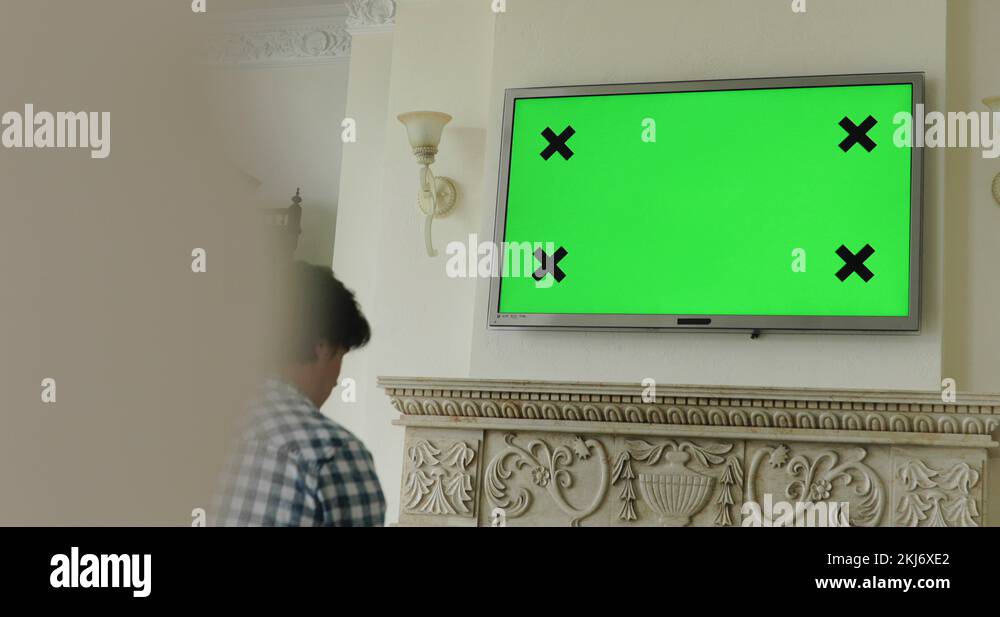 Man switching the channels with the remote control during watching TV ...