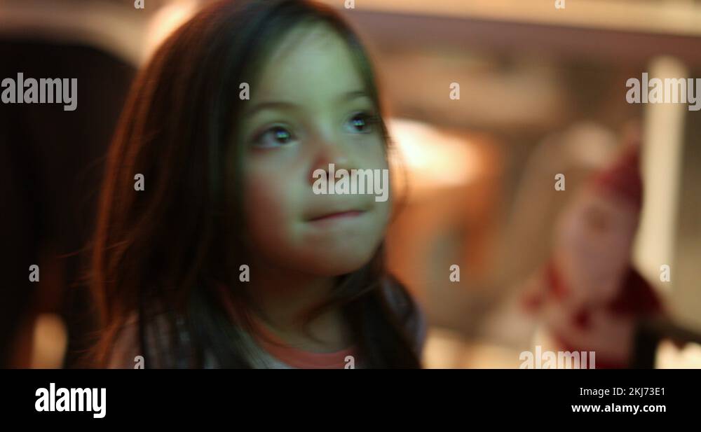 Little girl child watching TV screen at night. Small kid hypnotized ...