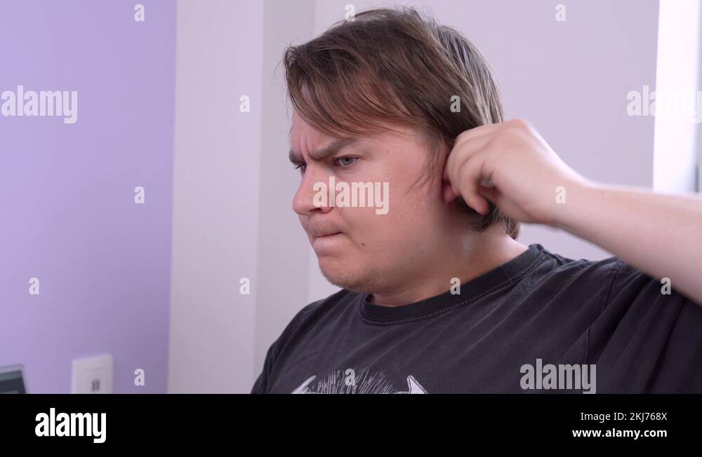 man with angry face expression inserts the curled paper swabs into his ...