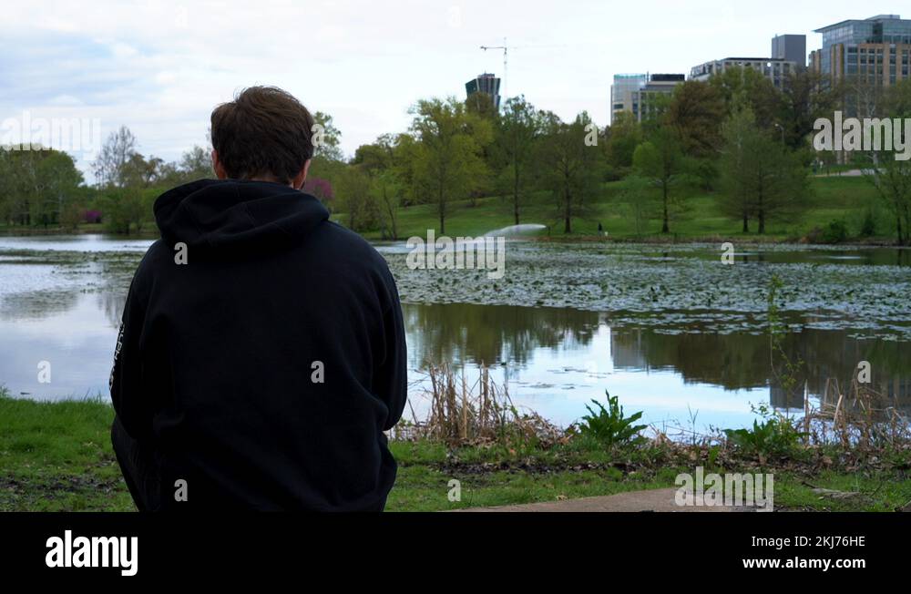Beautiful footage of person overlooking a lake and city at Forest Park ...