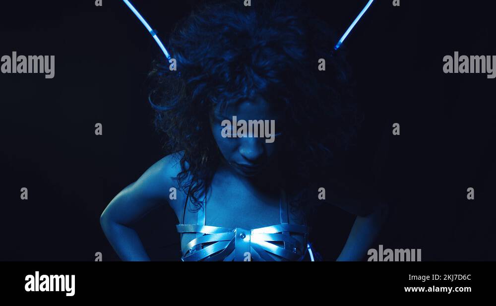 Beautiful young model lifts up her head, fashion show, blue lighting ...