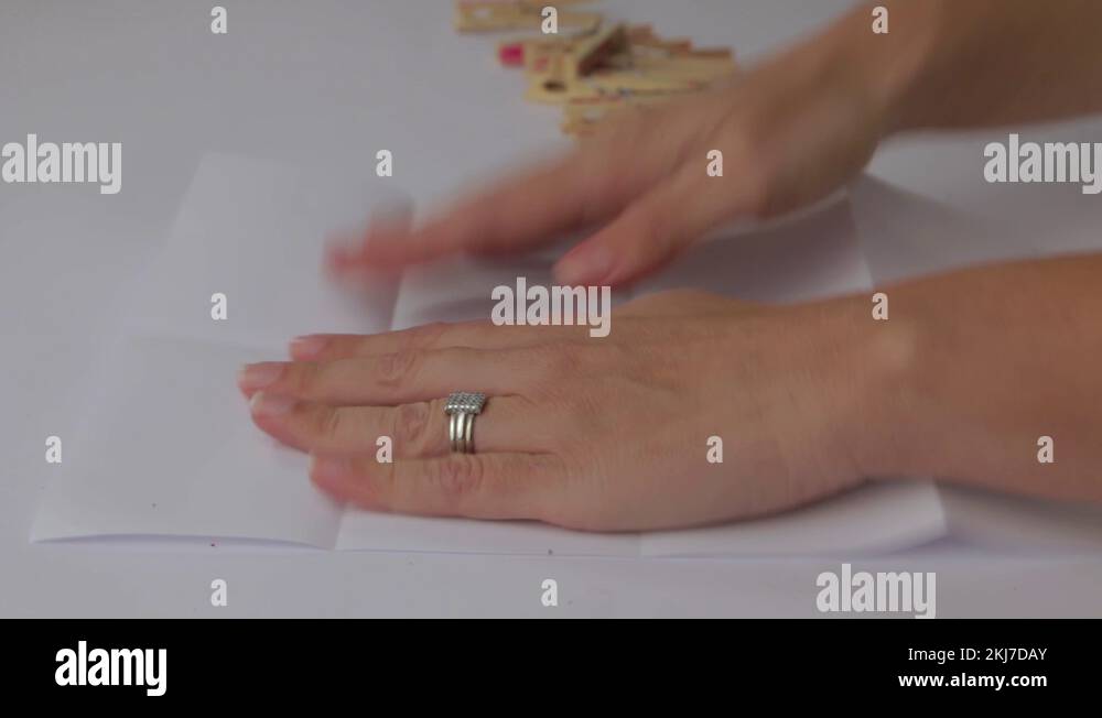 Close up of woman unfloding a piece of paper which is divided into ...