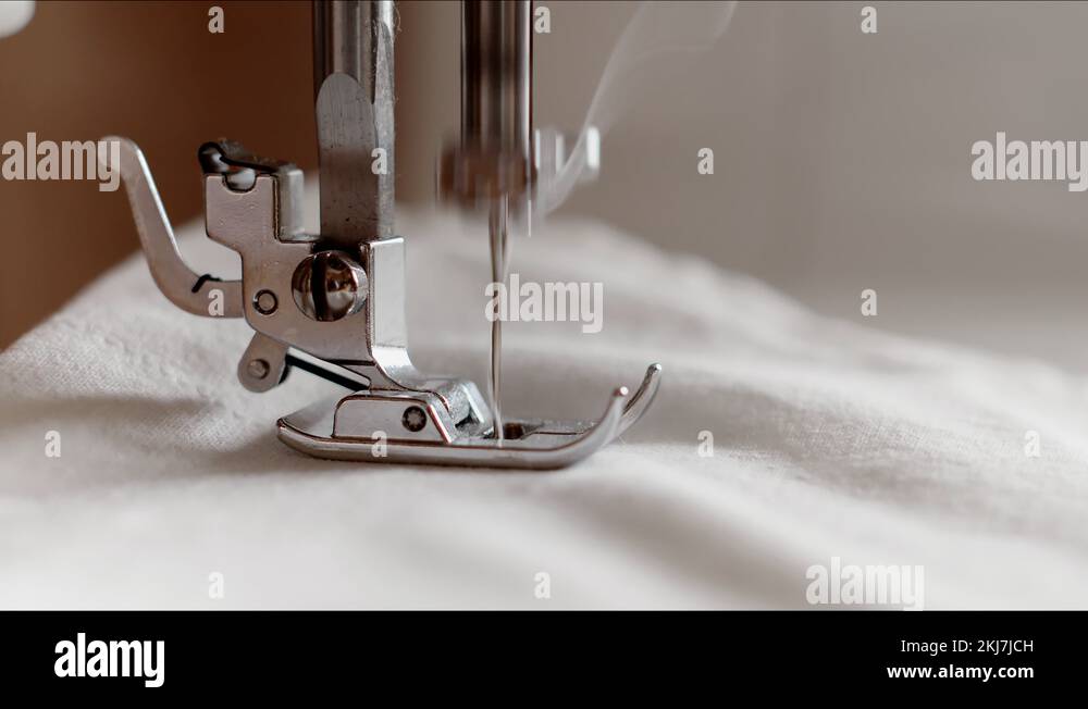 The needle of a sewing machine makes a thread stitch. Sewing white ...
