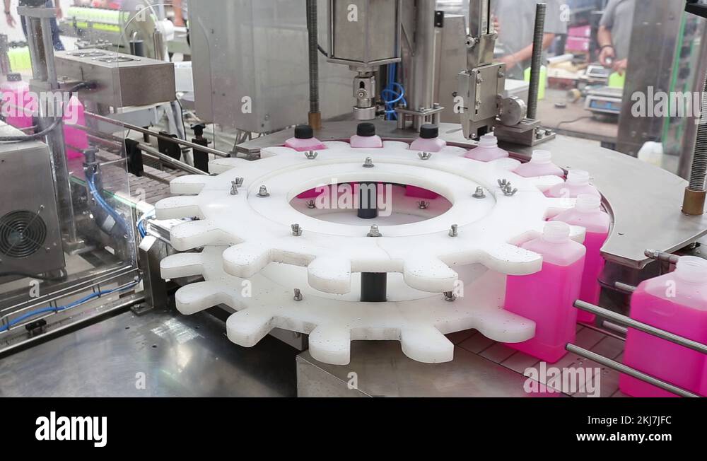 Overview of a bottle capping machine during a filling up process on an ...