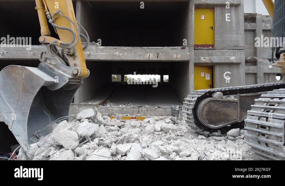 Drone flight through a digger and an old parking garage that is about ...