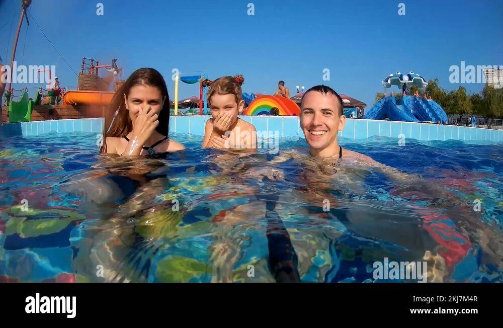 Funny family of three swim and diving in swimming pool on summer ...