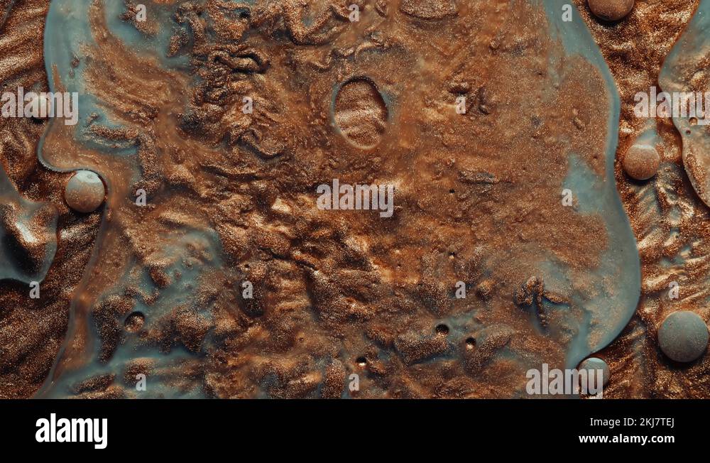 Gold and bronze paint flow. Sparkling particles, ink drops. Liquid ...