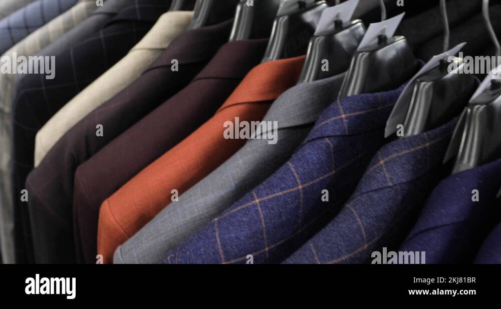Menswear classical different suits on hangers in row in clothing shop ...