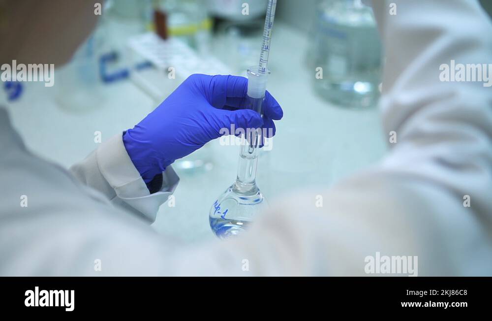 worker chemist filling pouring test tube with liquid reagent flask Spbd ...