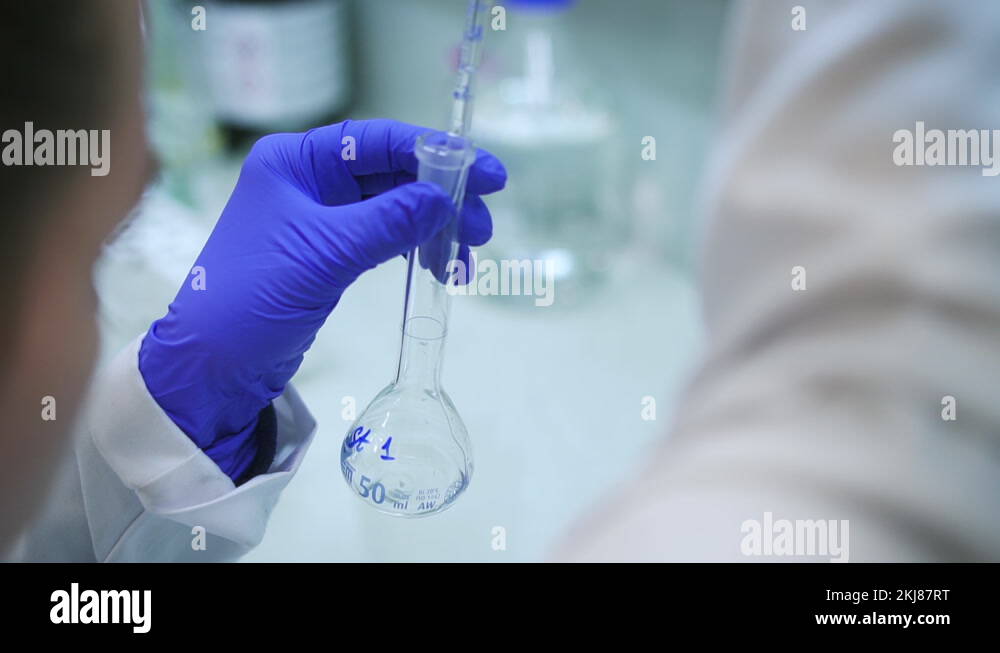 Scientist dripping liquid into test tube flask Spbd. Closeup. Liquid ...