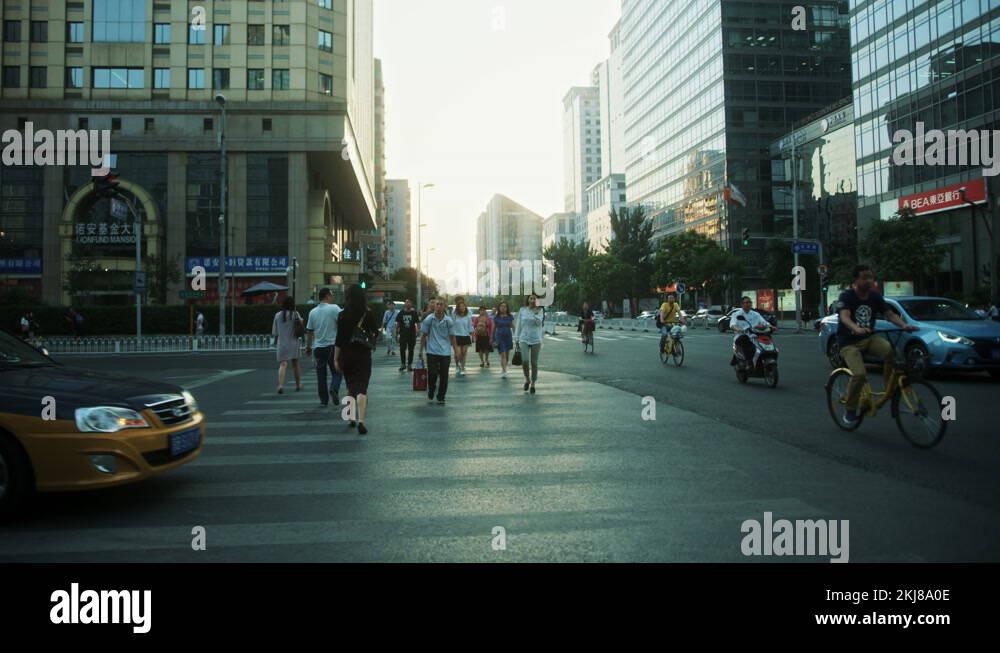 Crowd of Chinese women and men cross crosswalk at green light of ...