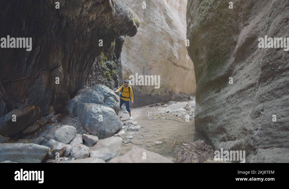 Man tourist hiking in mountain gorge with river Stock Video Footage - Alamy