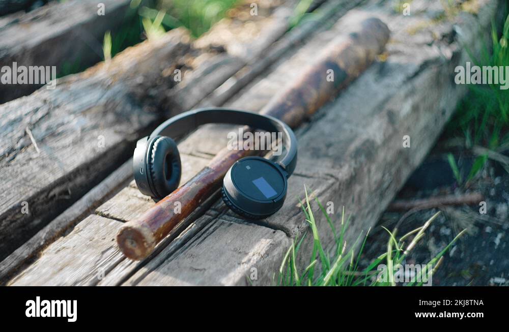 The guy picks up headphones and a baseball bat from a fallen log. Close ...