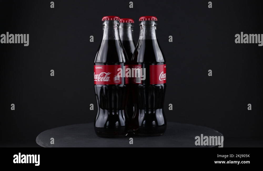 three bottles with red coca-cola classic logo rotating and stopping ...