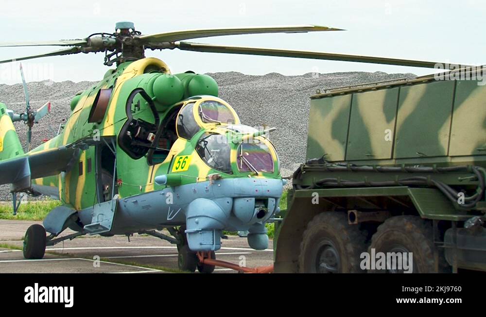 Tractor tows military helicopter Mi-24 / Mi-35 (Hind) in direction of ...