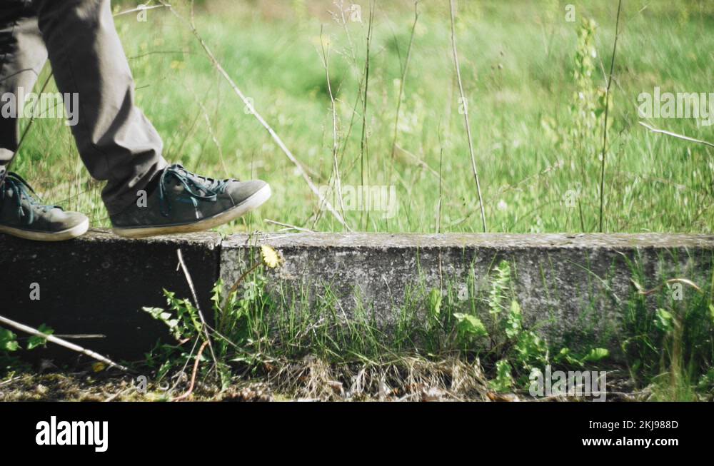 Your feet go along the curb from left to right. Close up. Walk around ...