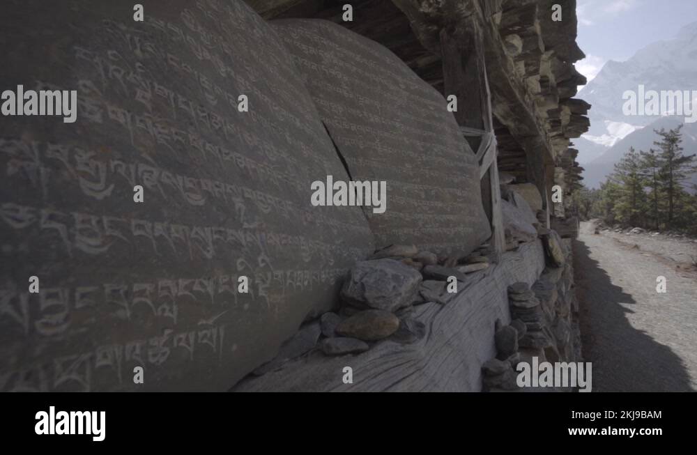 Ancient sanscrit tablets on a Himalayan mountain trail. The camera pans ...