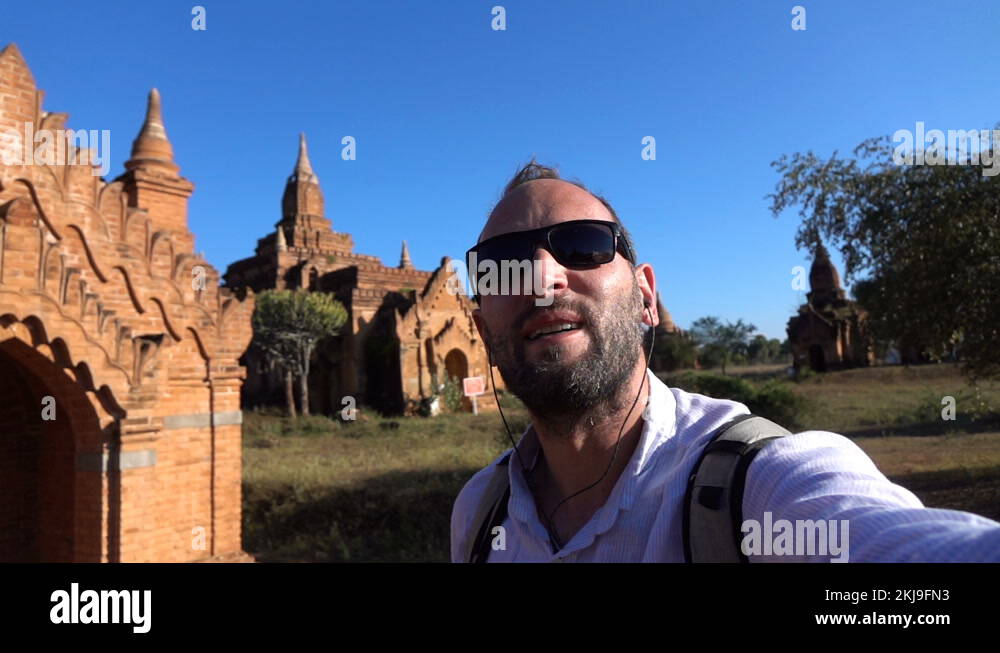 Young happy man walking, sightseeing famous Bagan temples in Myanmar ...