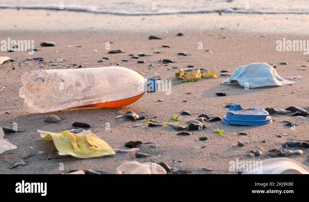 Disposable face masks and plastic debris on the beach in surf zone ...
