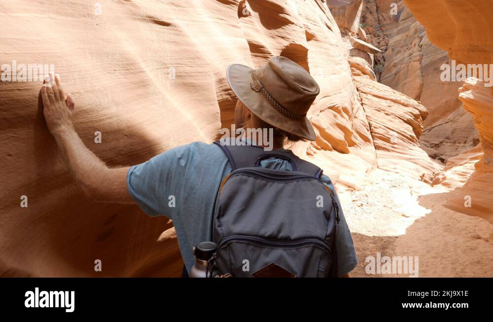 Man exploring Antelope Canyon. Young man hiker walks trough narrow ...