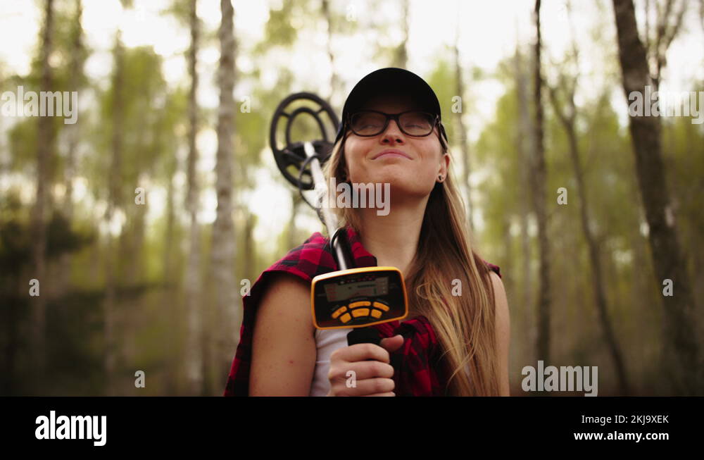 Young woman explorer in the forest with the metal detector on her ...