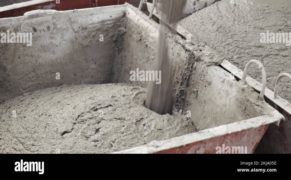 Liquid cement mortar poured into metal building pallet, delivering ...