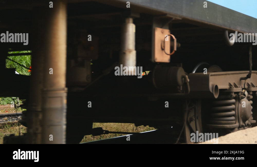 Spinning steel wheels of the train moves along the rail track ...