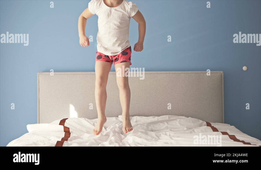 Frolicsome little girl having fun jumping on bed Stock Video Footage ...