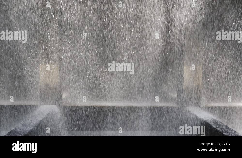 The rapidly falling water forms a wall of water droplets, solid ...
