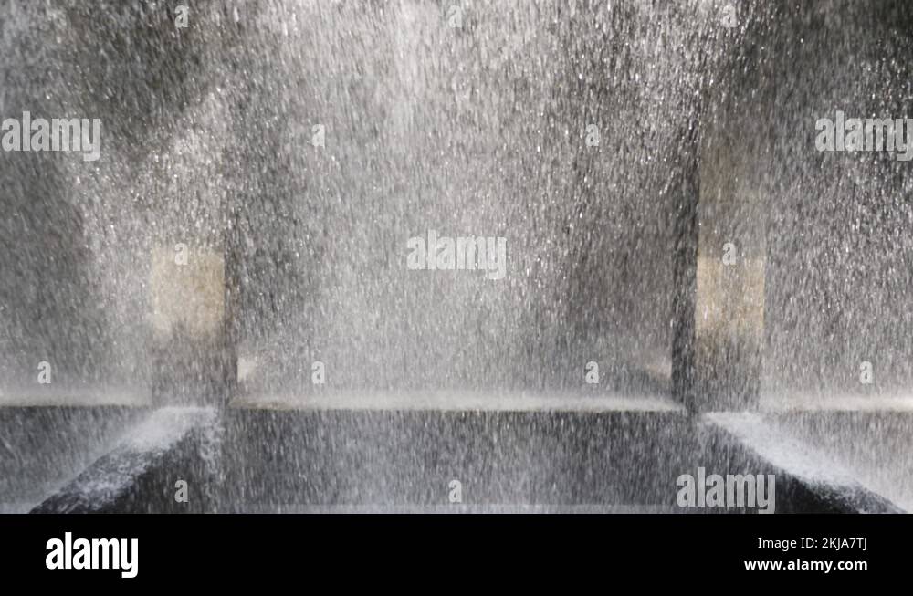 The rapidly falling water forms a wall of water droplets, solid ...